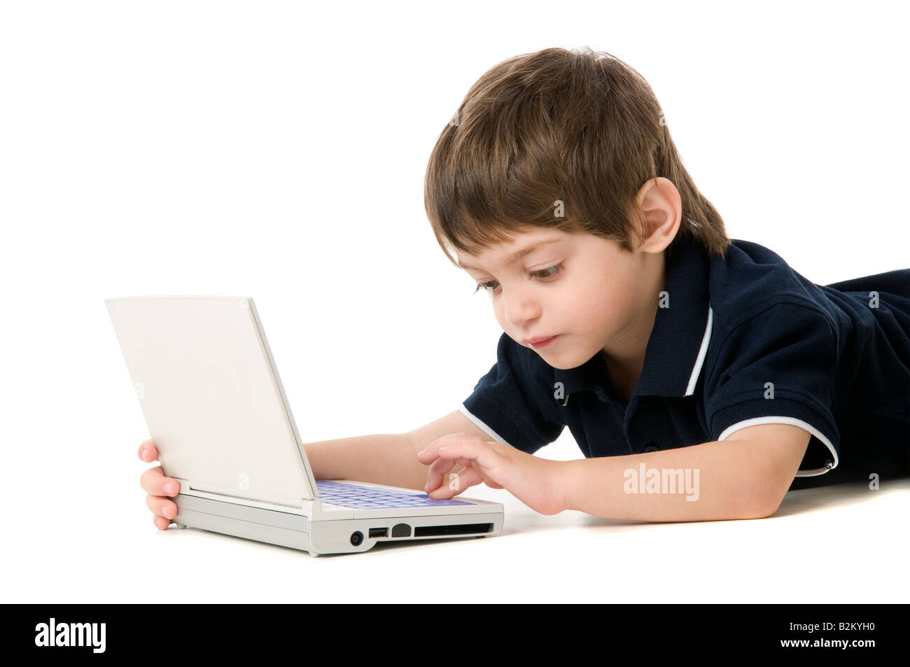 Child playing with the laptop lying on the floor Stock Photo - Alamy