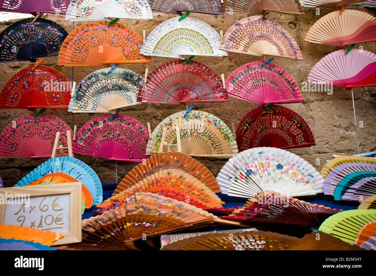 A colourful assortment of various sizes of fans displayed for sale at ...