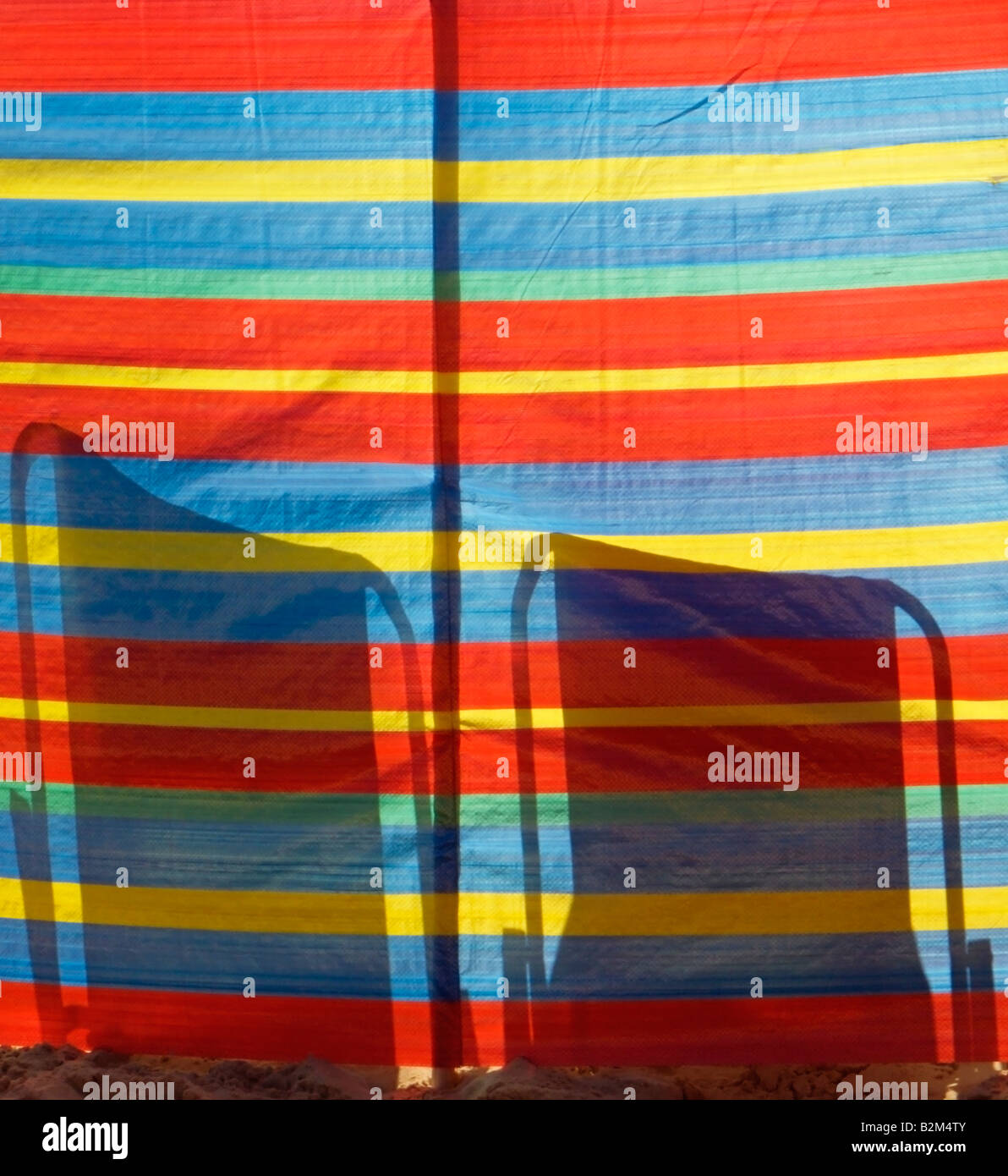 Silhouette of Beach Chairs and Colourful Wind Break Stock Photo - Alamy