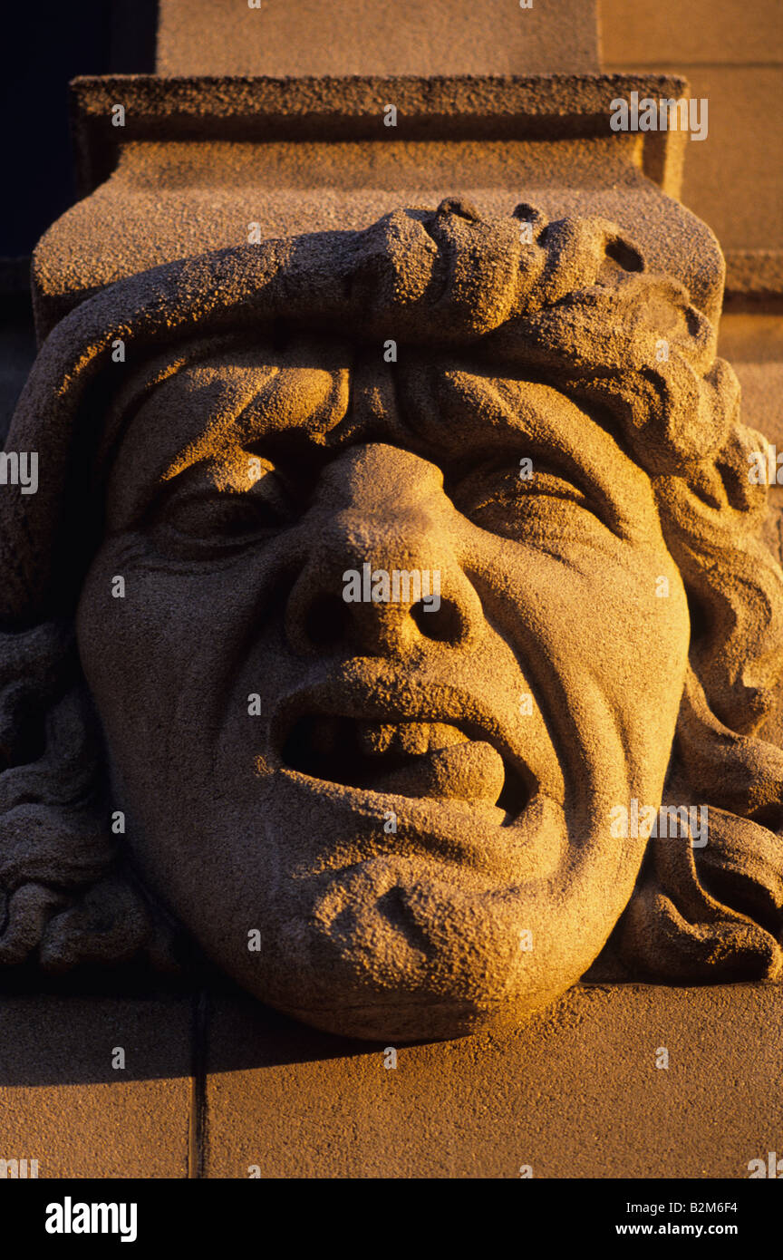 Gargoyle on side of building at sunset grotesque expression along the ...