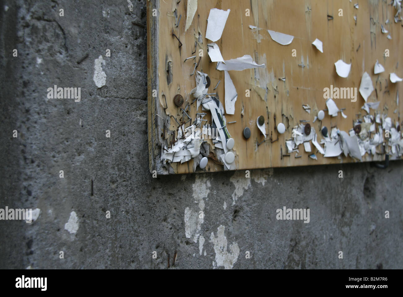 old dirty notice board on outside wall in town Stock Photo - Alamy