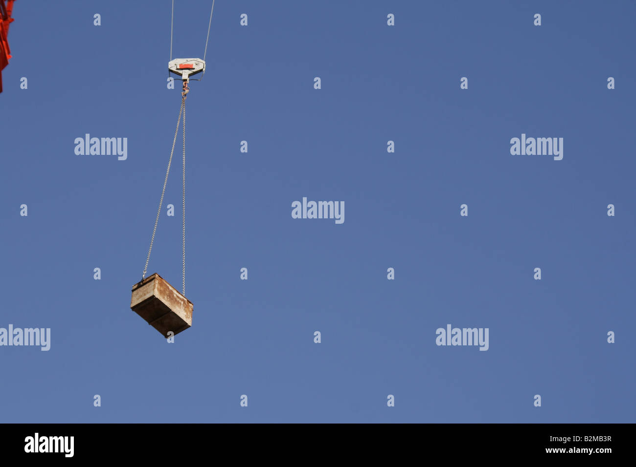 lifting crane with hanging load on building site Stock Photo - Alamy