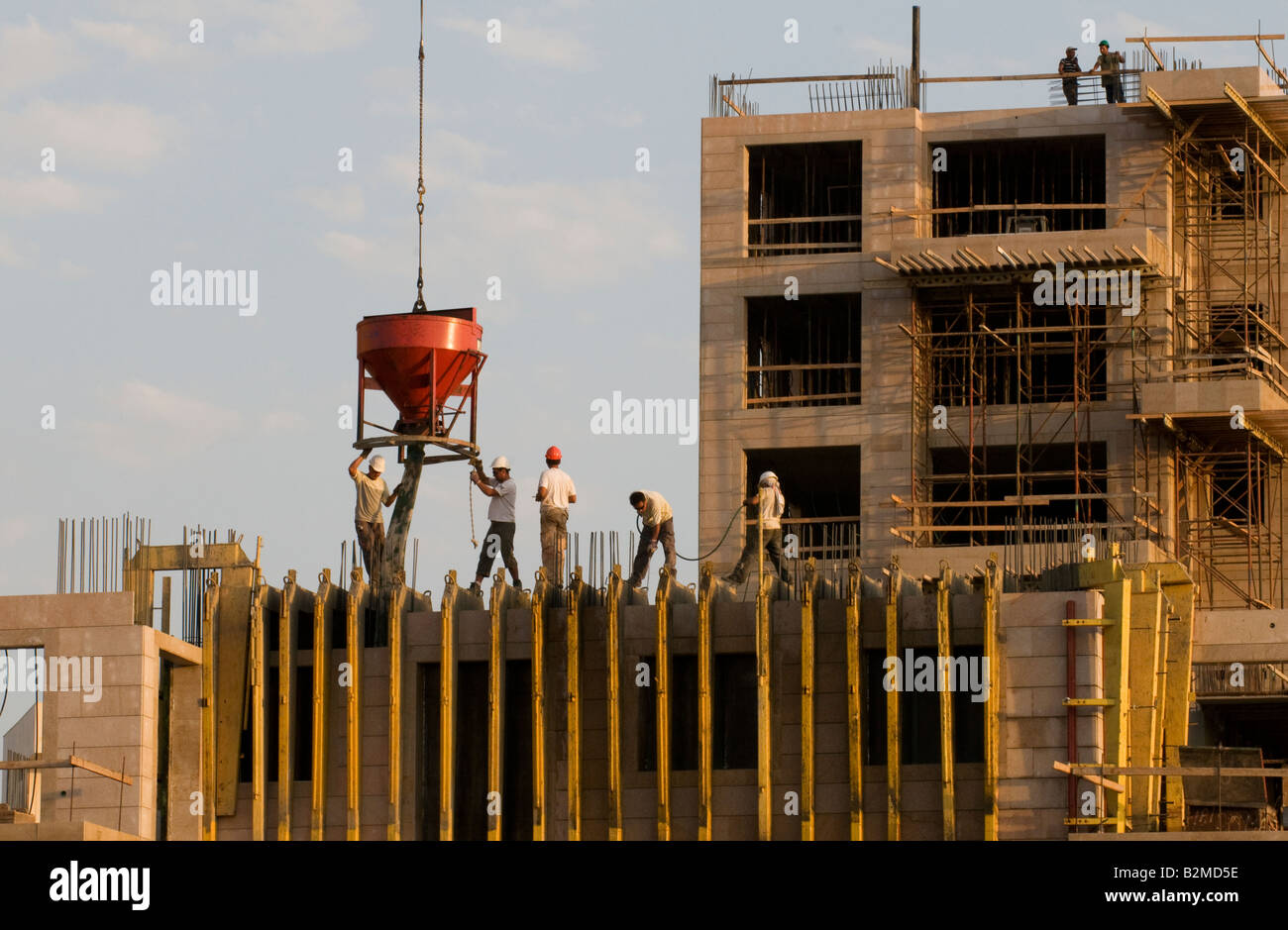 Construction crew casting concrete for the floor of a new apartment ...
