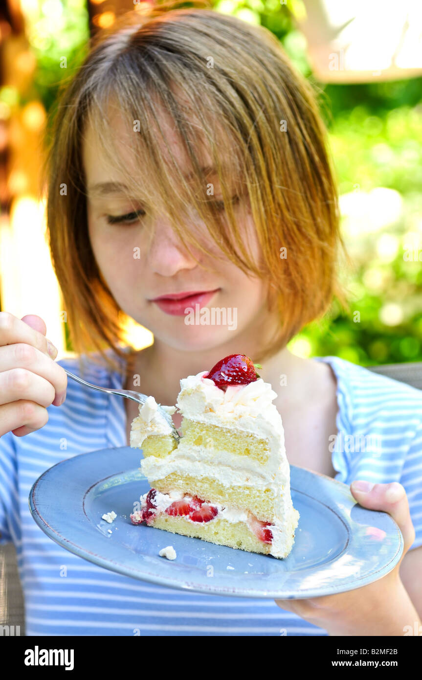 Teenage girl eating a piece of strawberry cake Stock Photo - Alamy