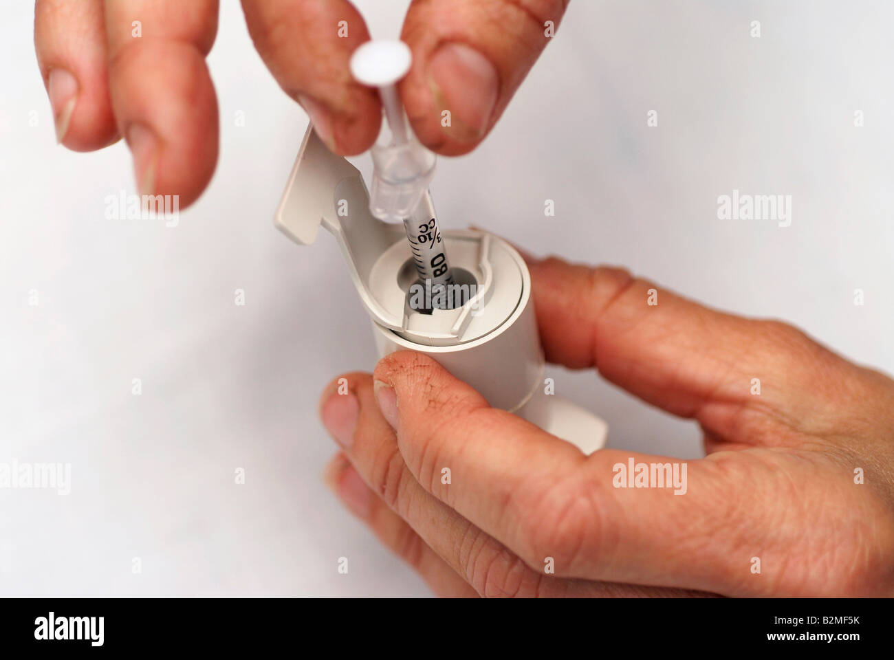 Diabetic inserting ^hypodermic syringe ^needle containing insulin into ...