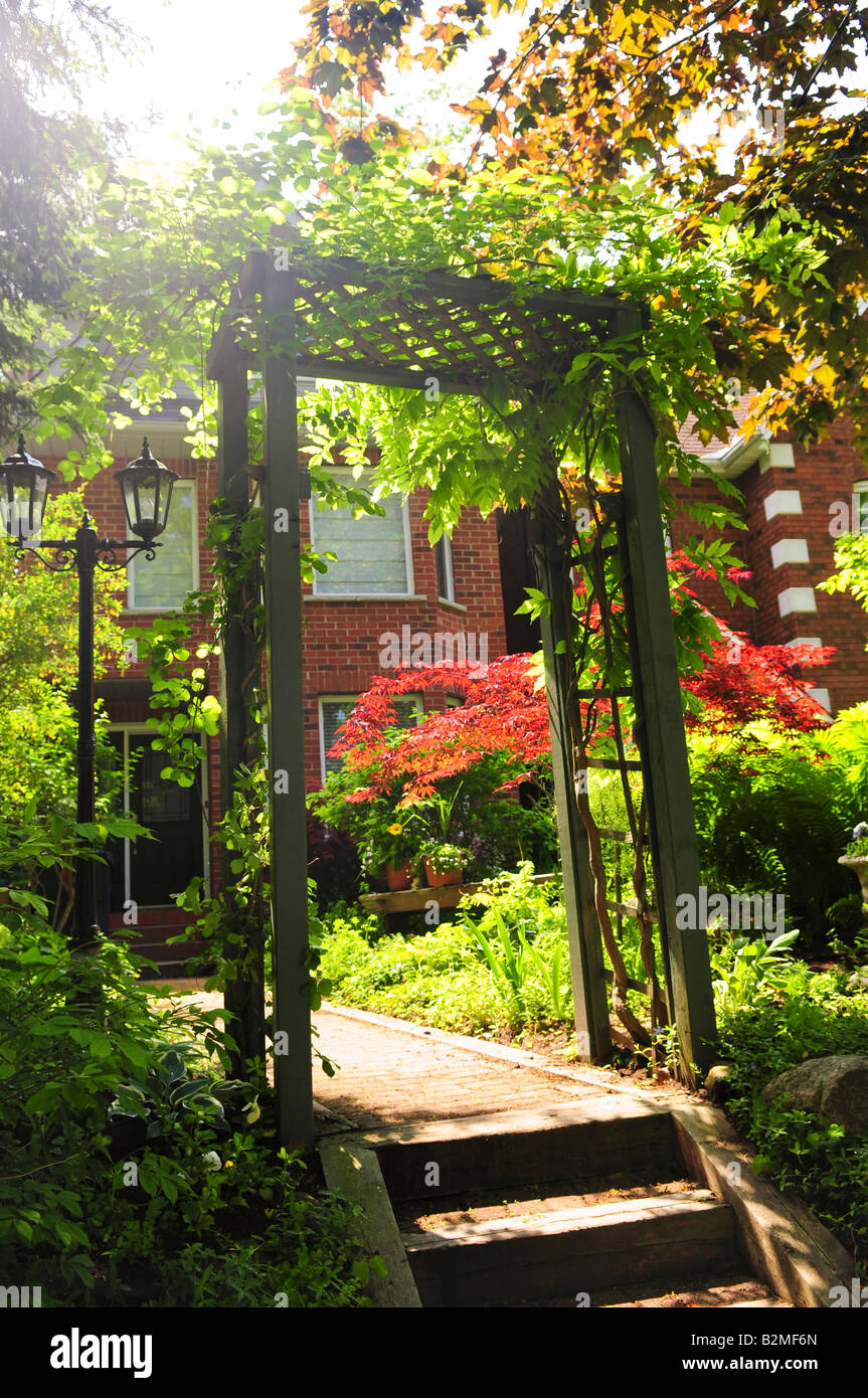 Landscaped front yard of a house with flowering garden and arbor Lens ...