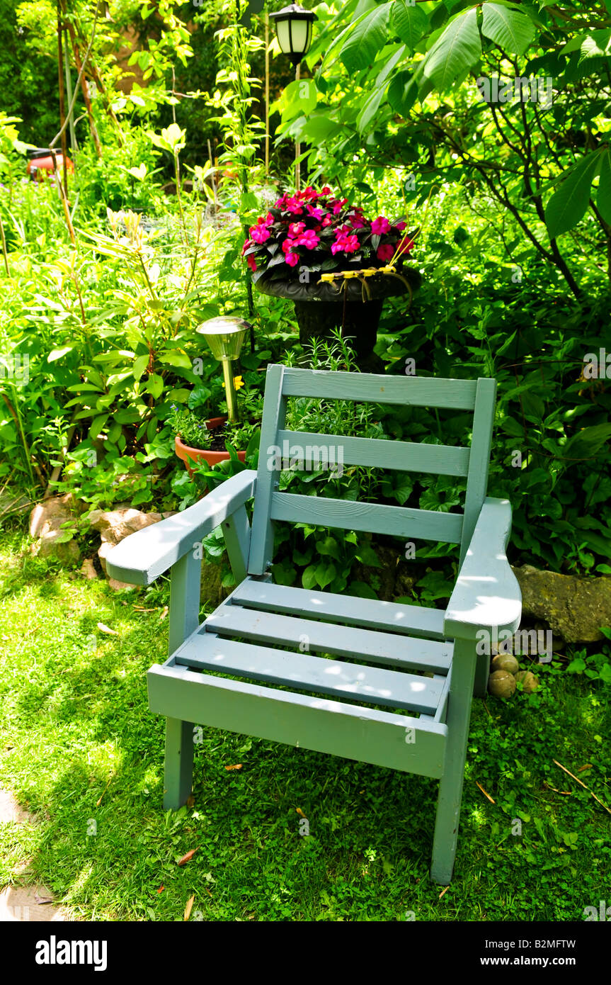 Wooden chair in a secluded corner of lush green garden Stock Photo - Alamy