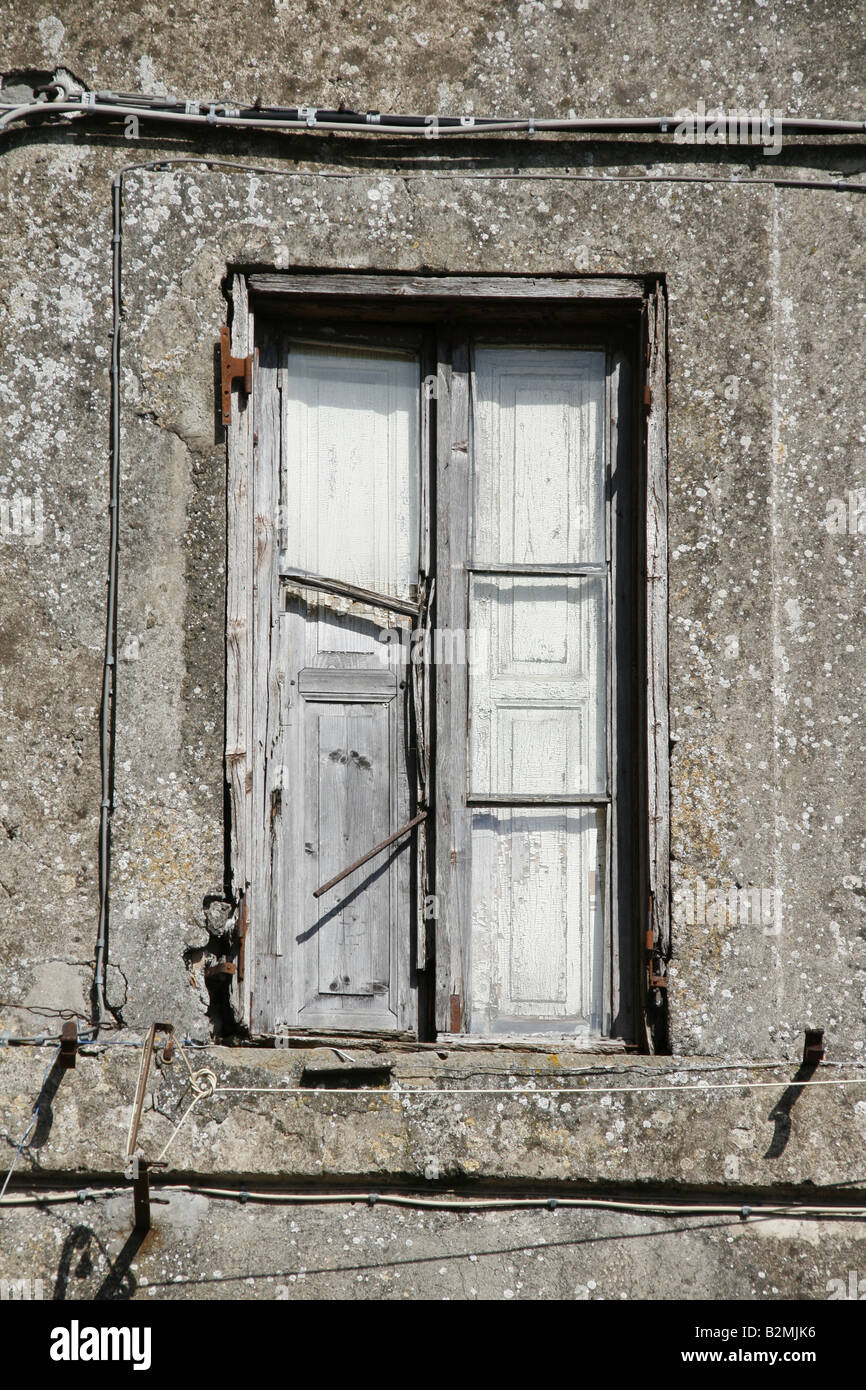 old window with damaged wooden frame on old derelict building property ...