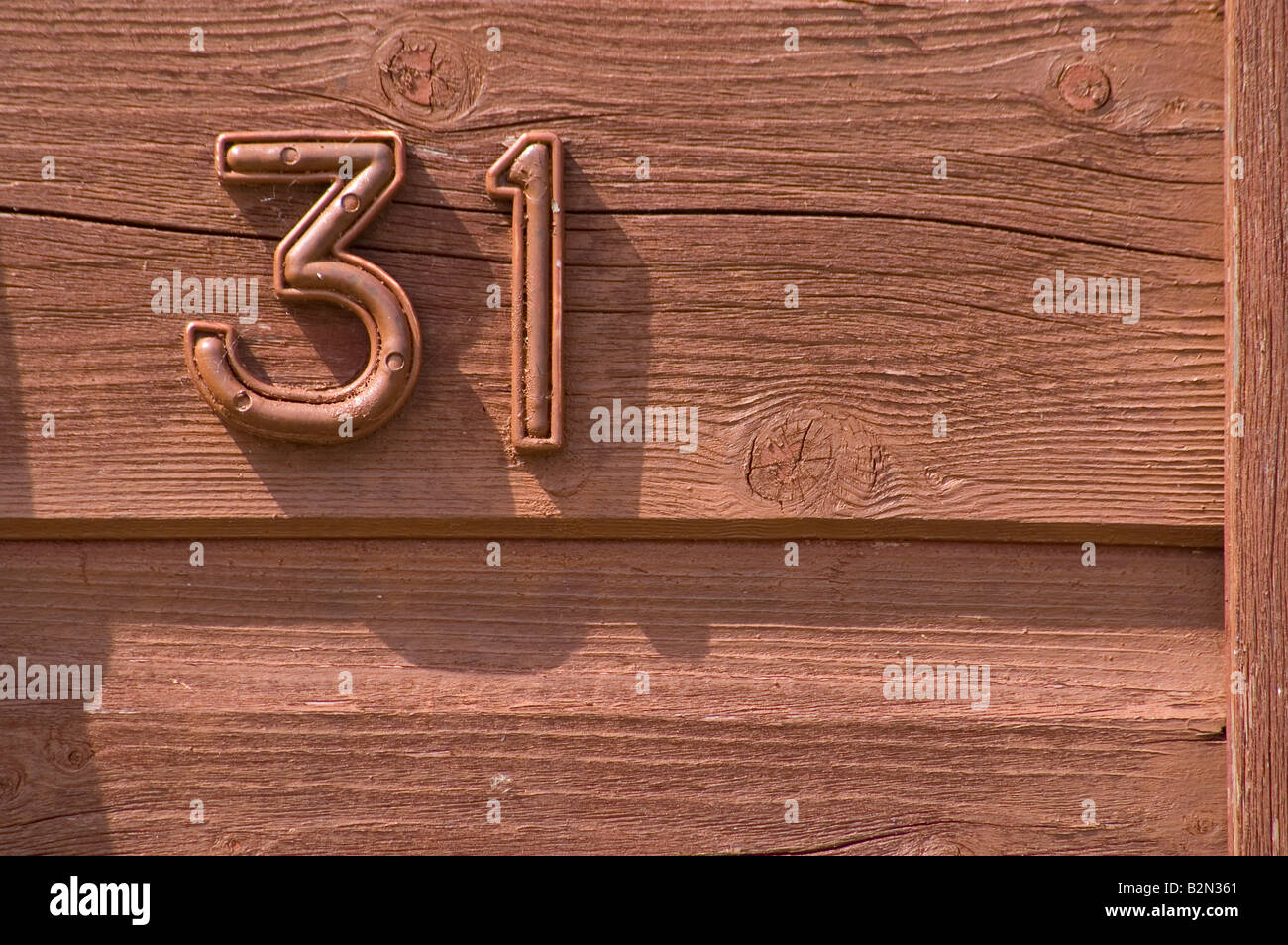 A plastic number "31" painted brown on an old wooden beach hut Stock ...