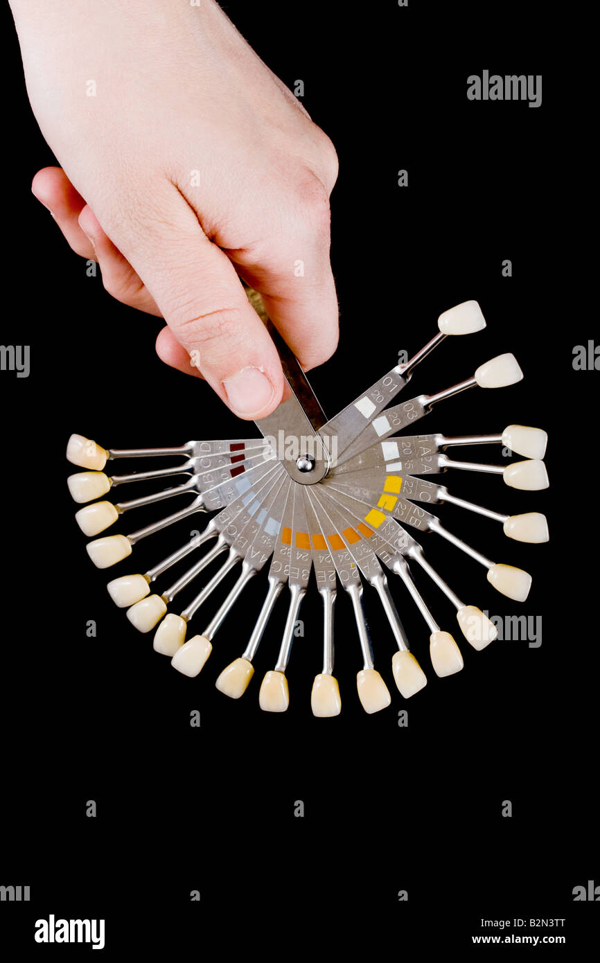 hand holding human teeth models isolated on black Stock Photo - Alamy