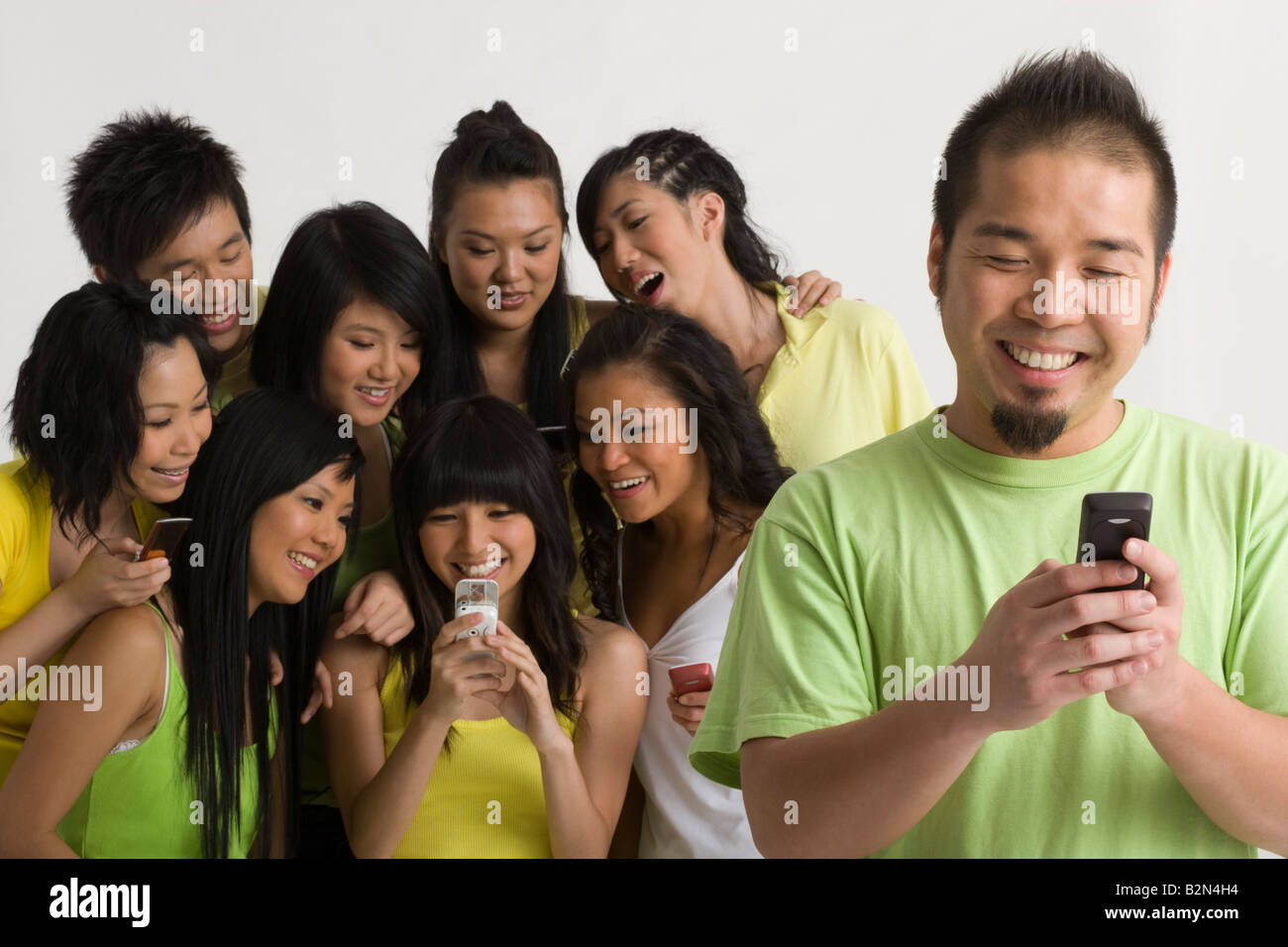 Close-up of a young man text messaging with his friends in the ...
