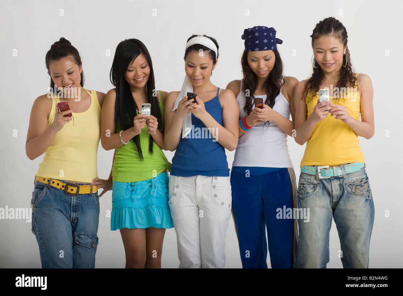 Five young women text messaging Stock Photo - Alamy