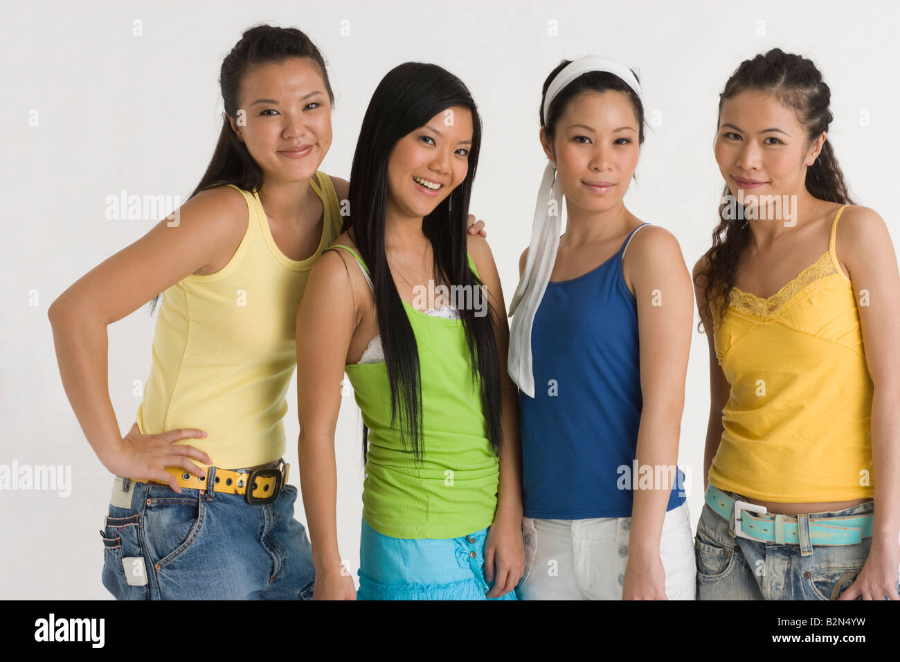 Portrait of four young women standing and smiling Stock Photo - Alamy