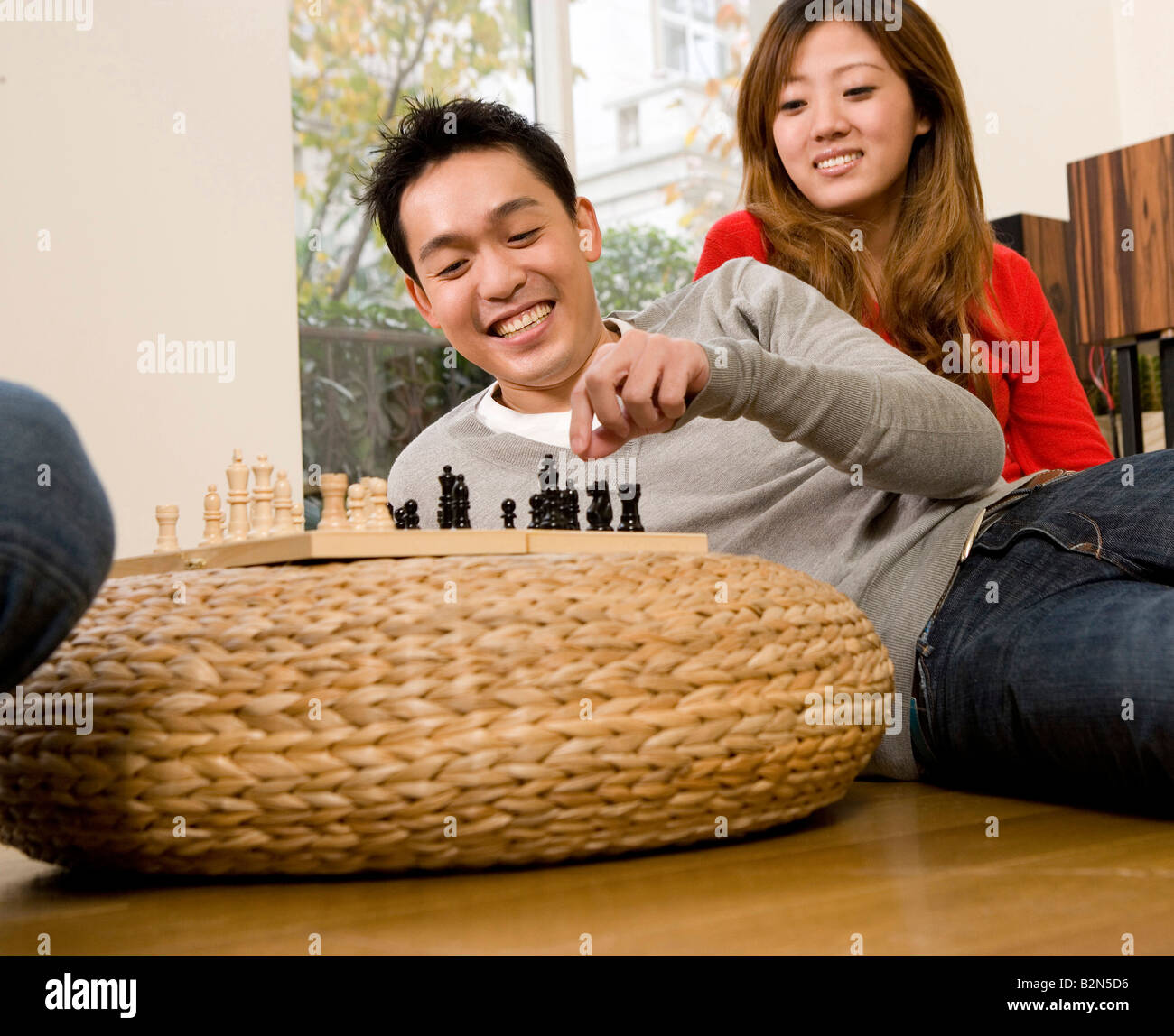 A cheerful young couple playing chess Stock Photo - Alamy