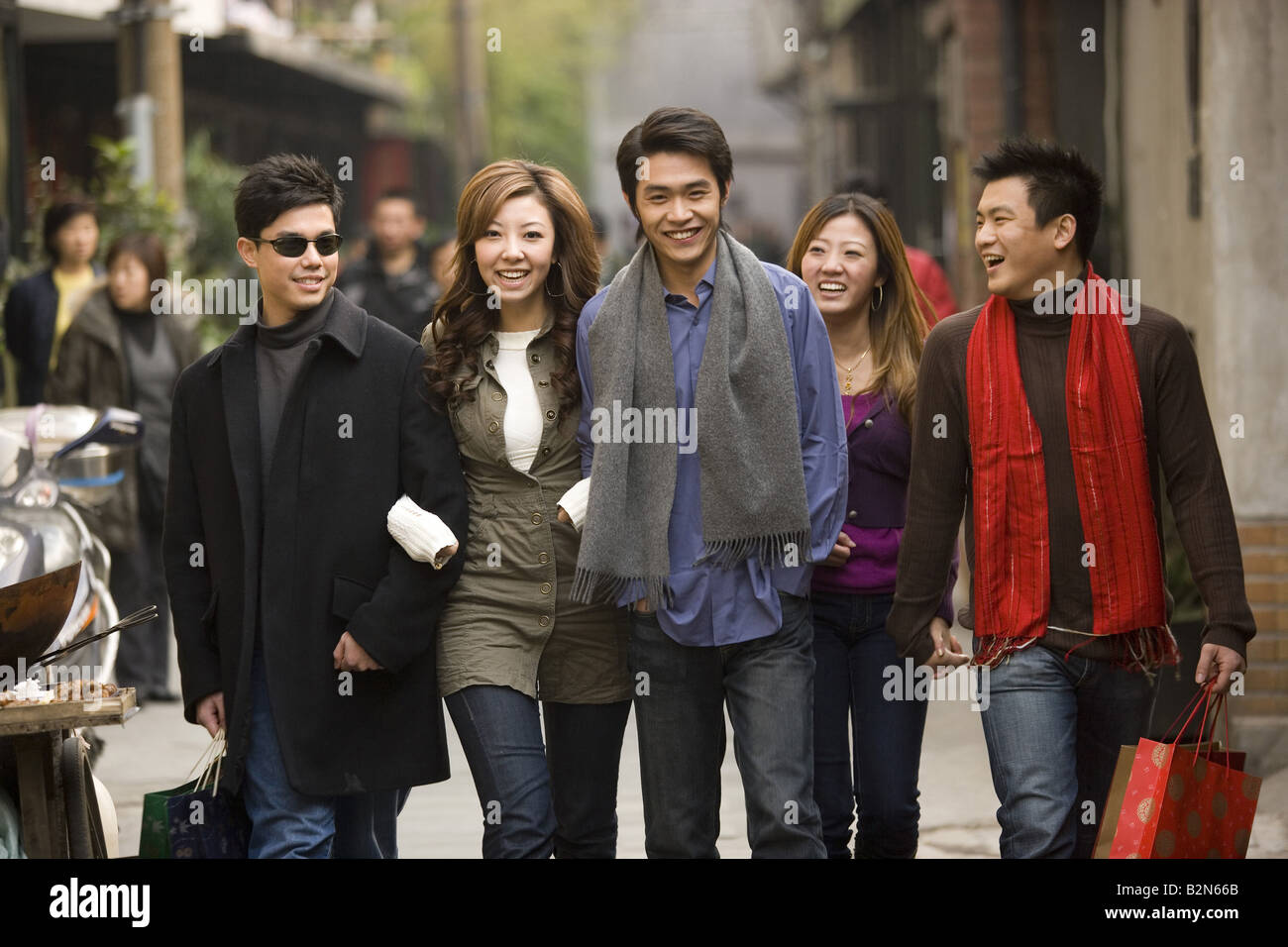 Portrait of friends walking together in a row Stock Photo - Alamy
