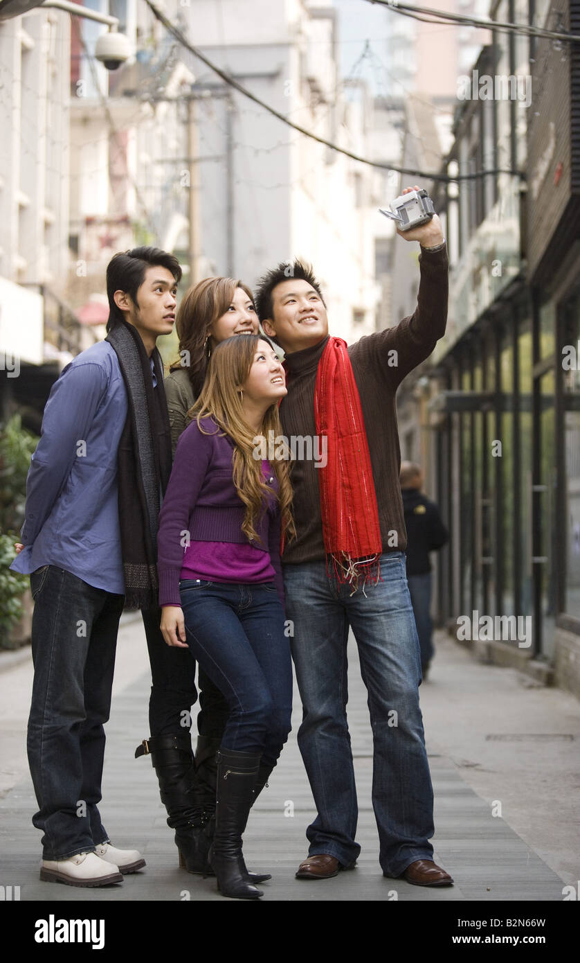 View of friends watching pictures in a camcorder Stock Photo - Alamy