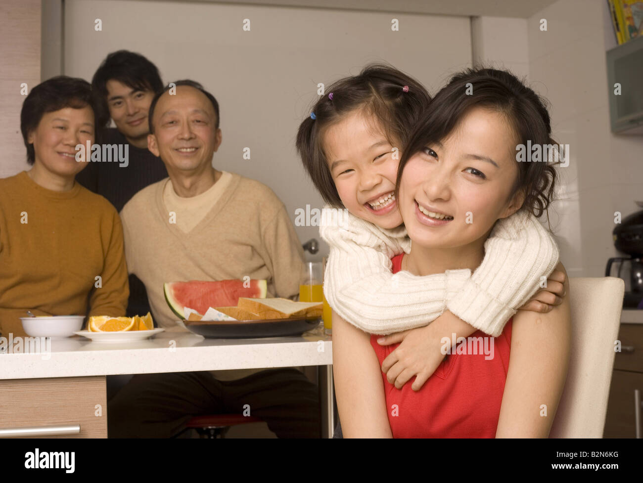 Portrait of a girl hugging her mother from behind with her family ...