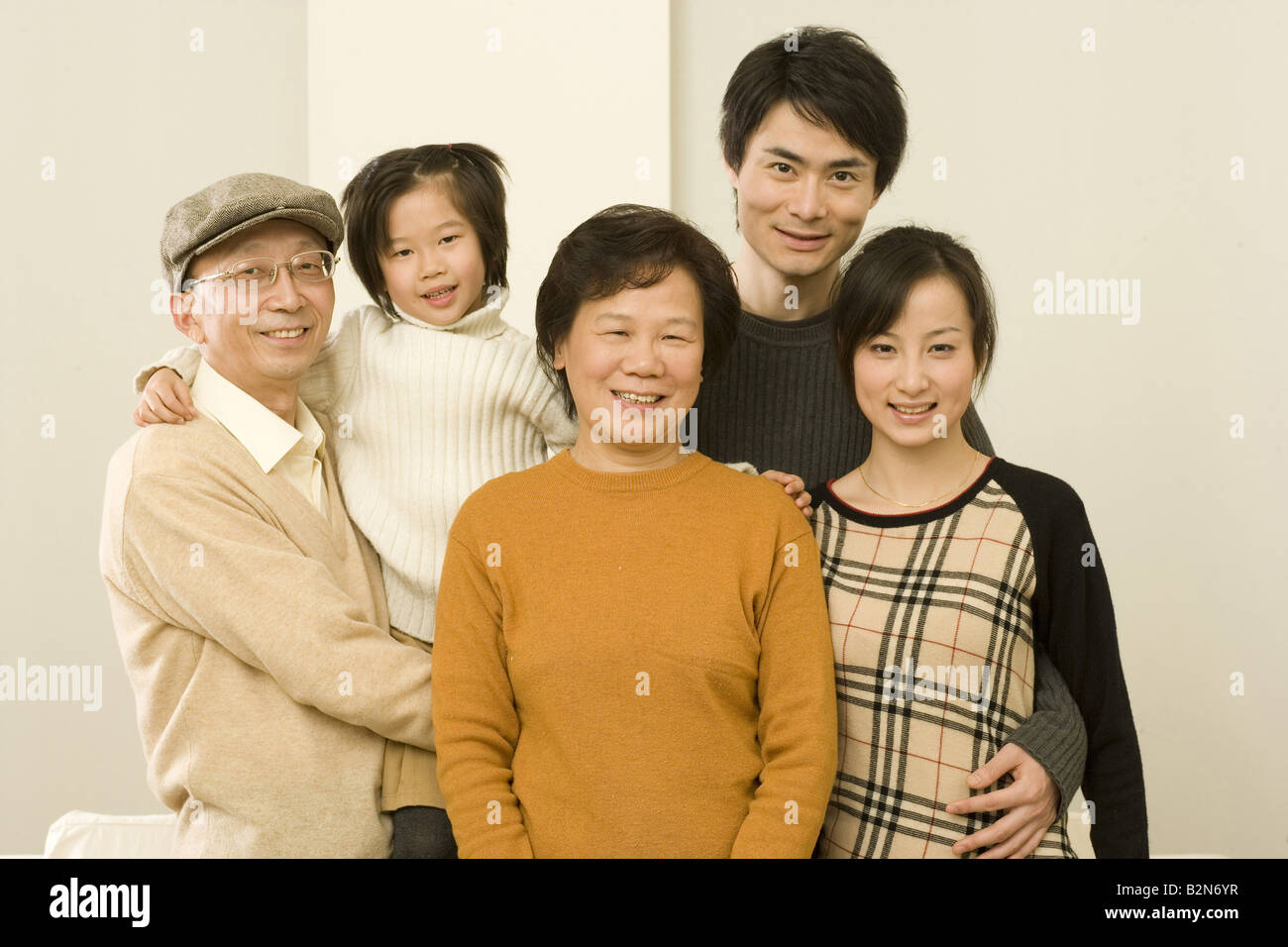 Portrait of a family sitting side by side Stock Photo - Alamy