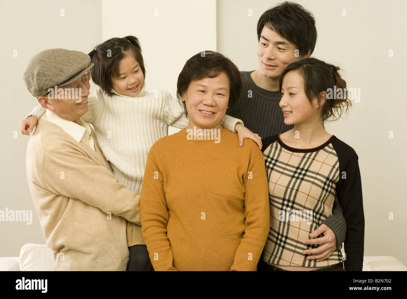 Portrait of a family sitting side by side Stock Photo - Alamy