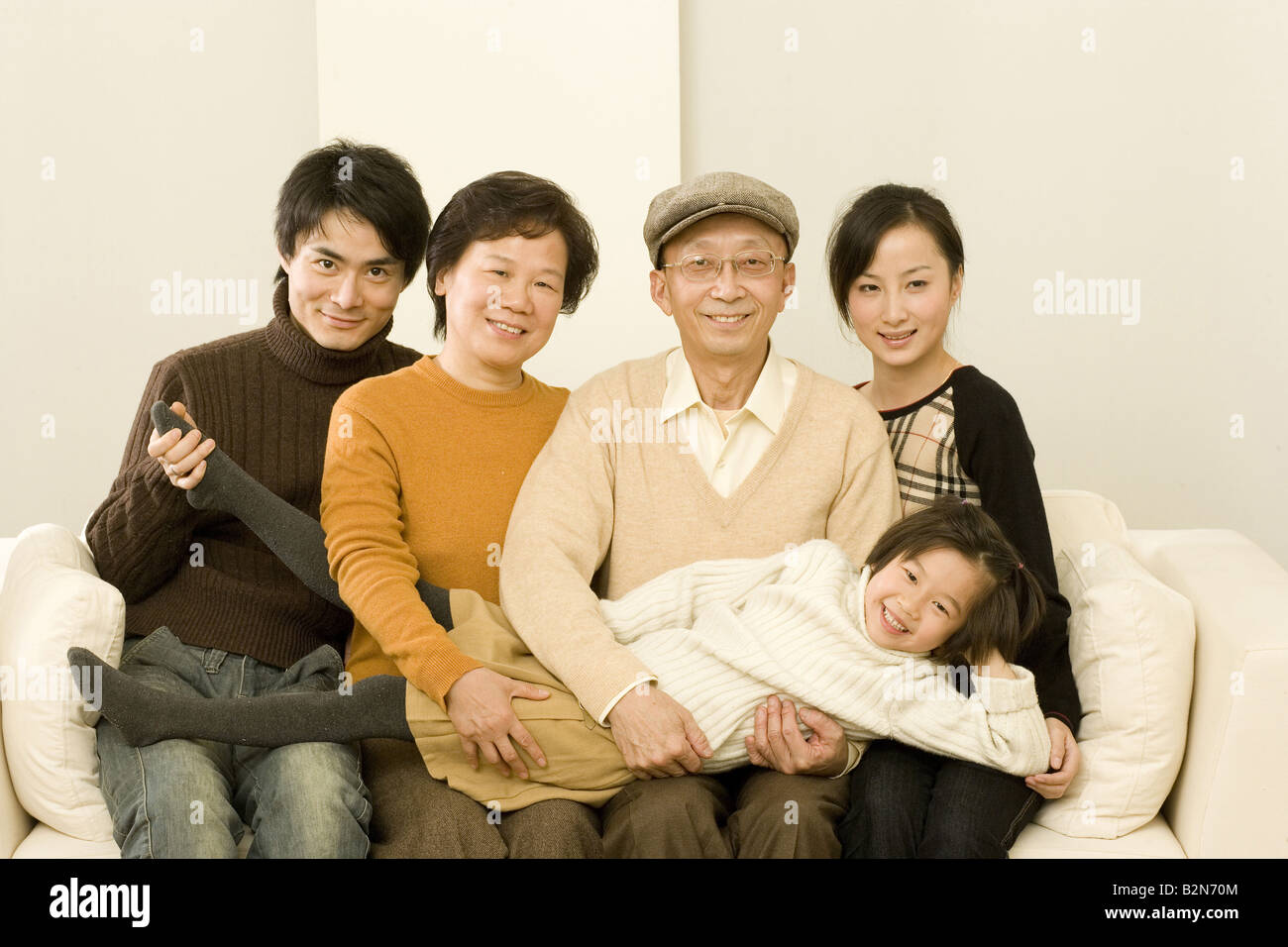Portrait of a three generational family sitting side by side Stock ...