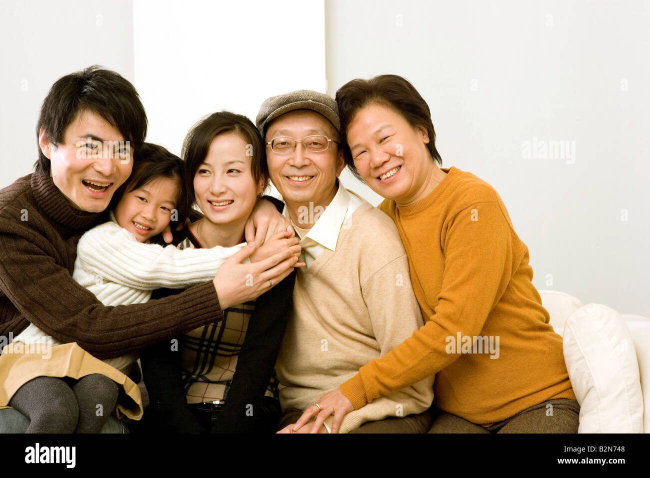 Portrait of a family sitting side by side Stock Photo - Alamy