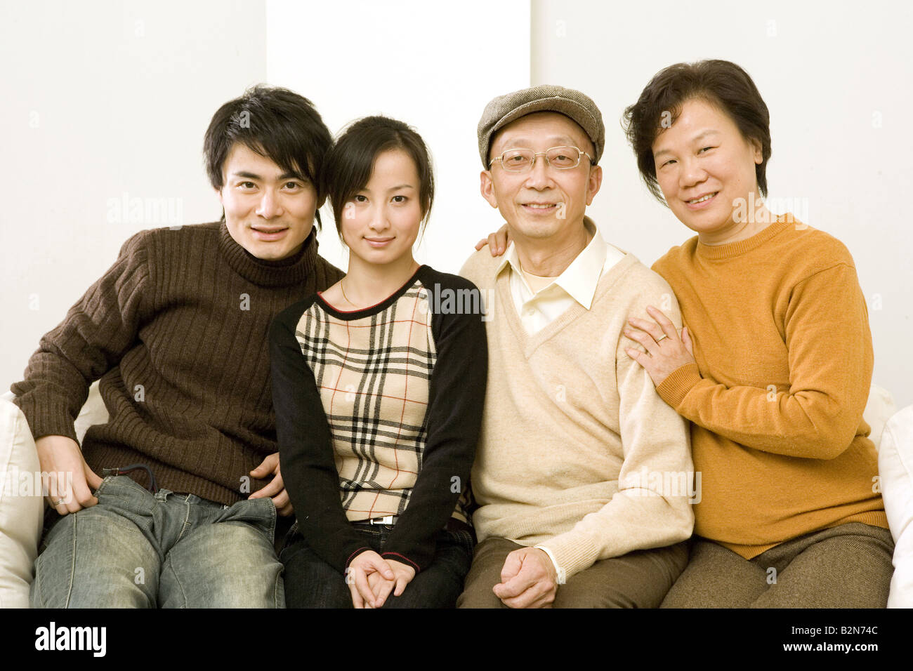 Portrait of a family sitting side by side Stock Photo - Alamy