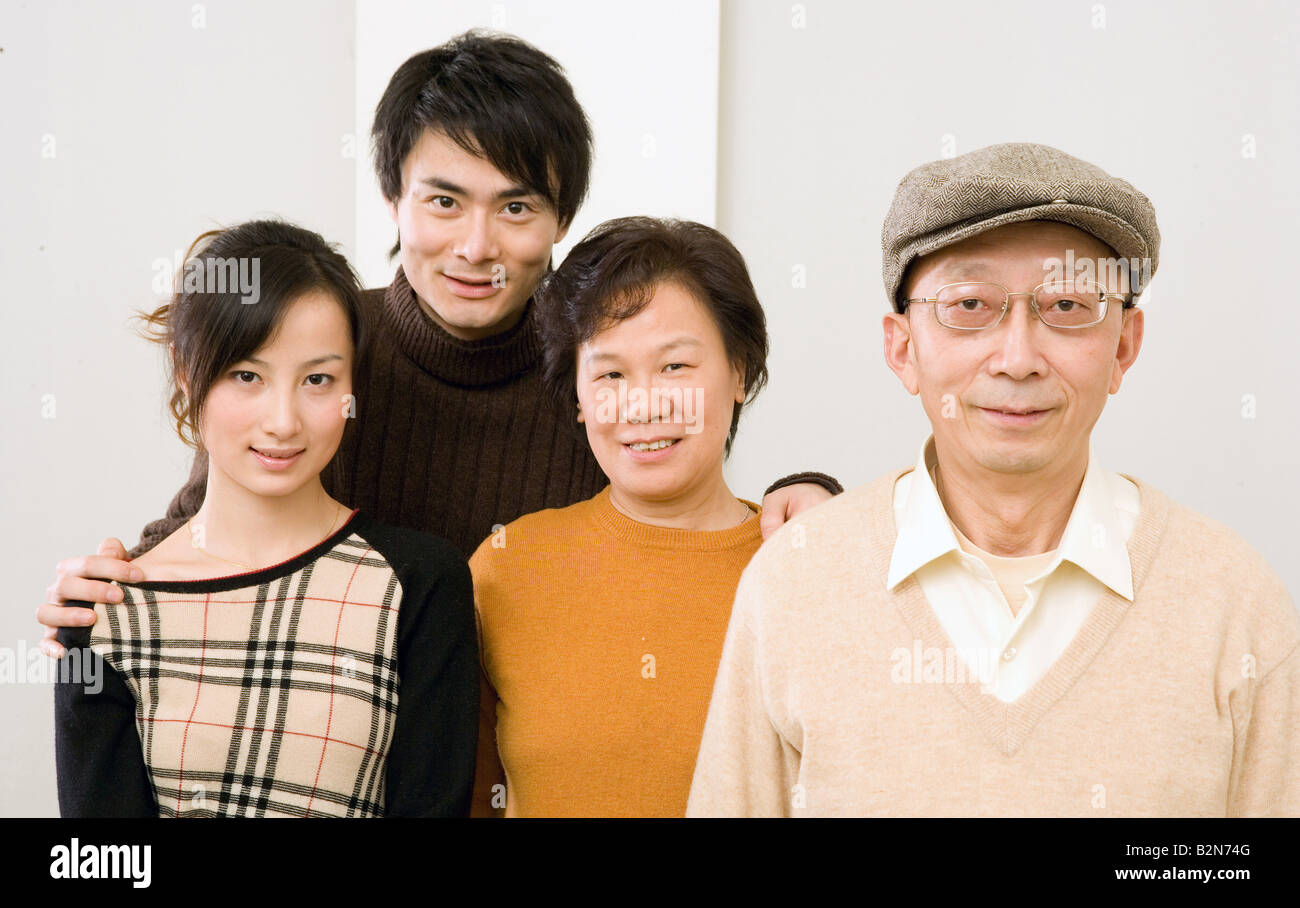 Portrait of a young couple standing with their parents and smiling ...