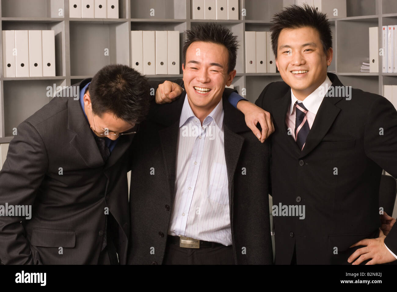 Three businessmen smiling in an office Stock Photo - Alamy