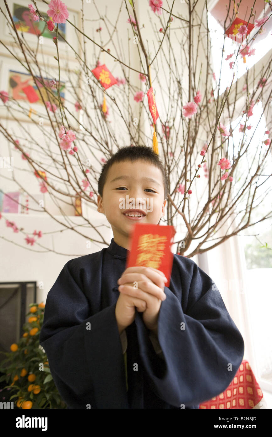 Boy smiling and holding a red envelope Stock Photo - Alamy