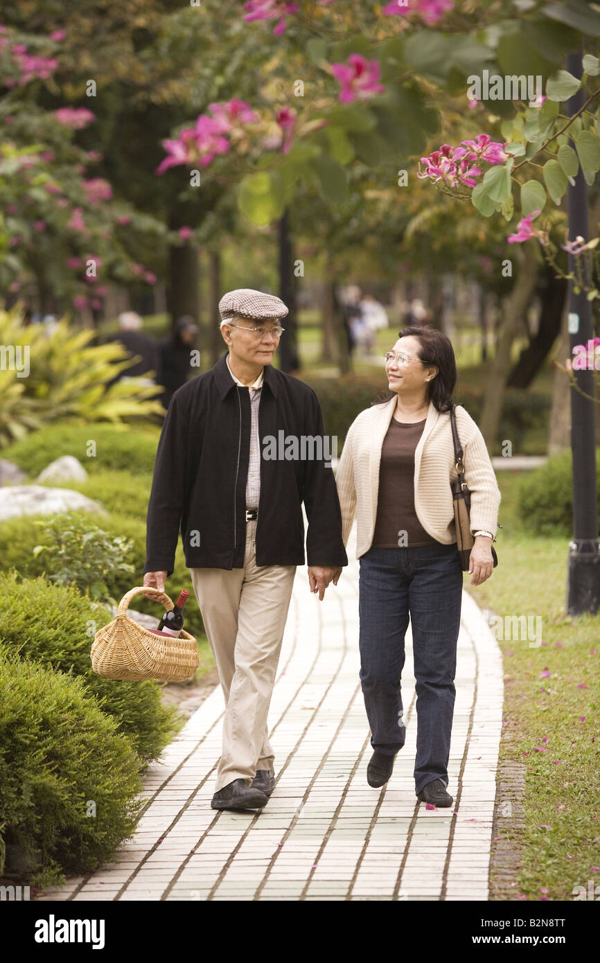 Senior couple walking in a park and smiling Stock Photo - Alamy