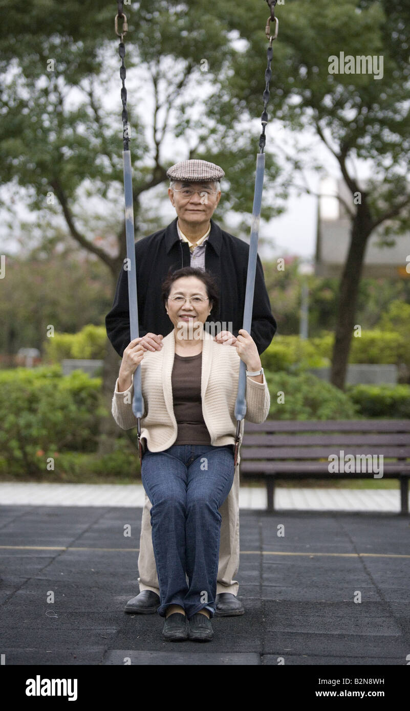 Man pushing a woman on a swing hi-res stock photography and images - Alamy