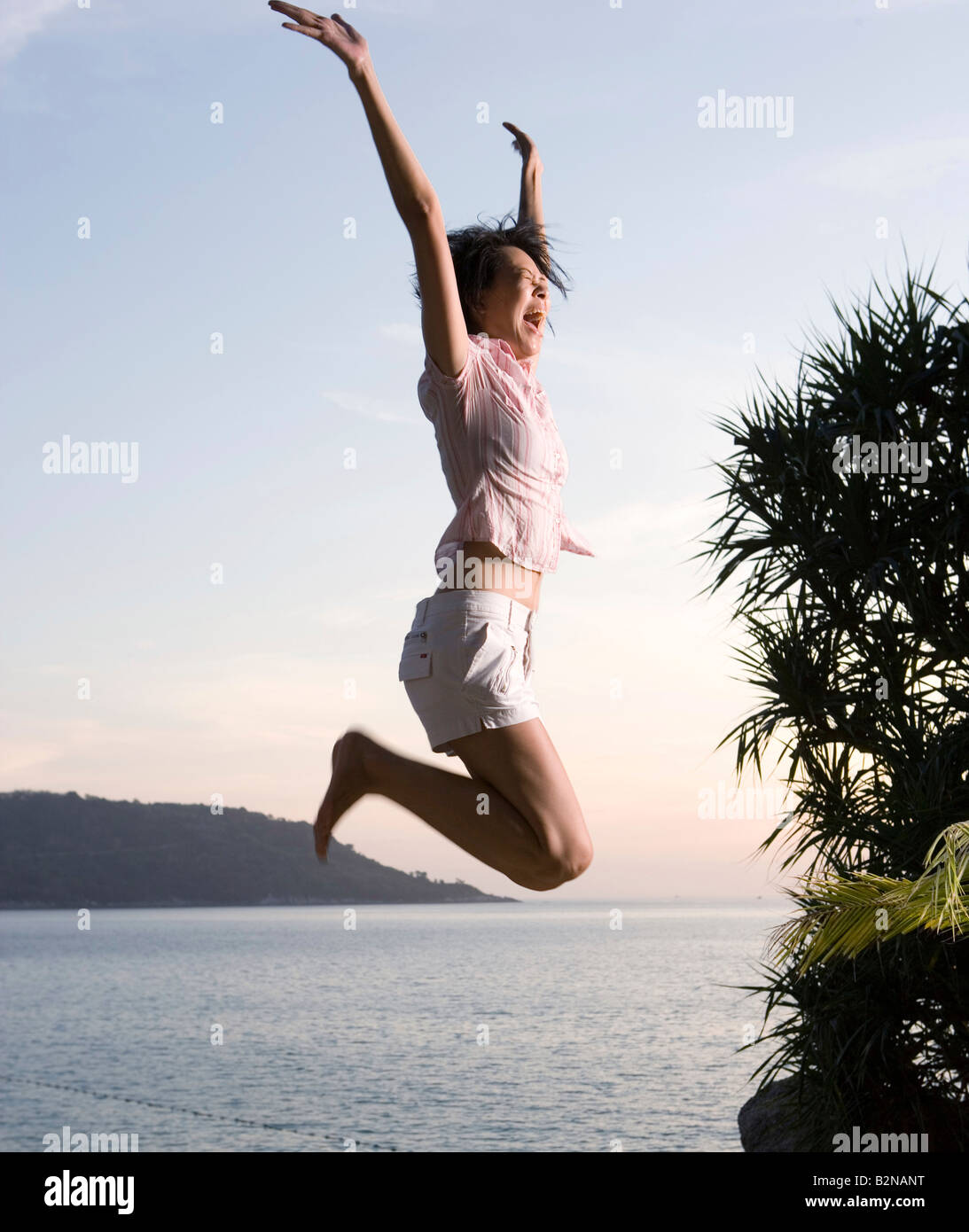 Side profile of a young woman jumping, Phuket, Thailand Stock Photo - Alamy