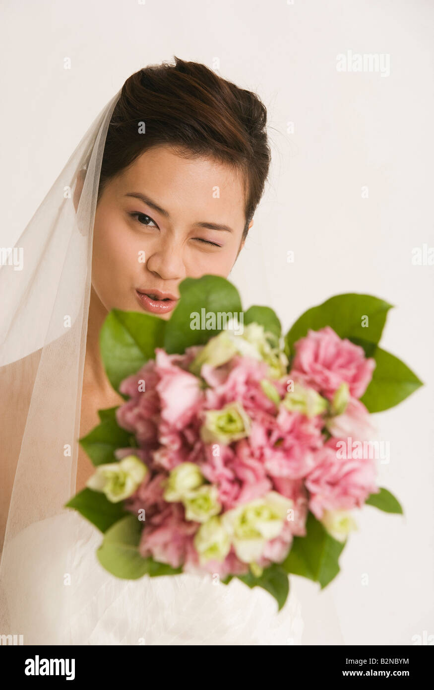 Portrait of a bride showing a bouquet of flowers and winking Stock ...