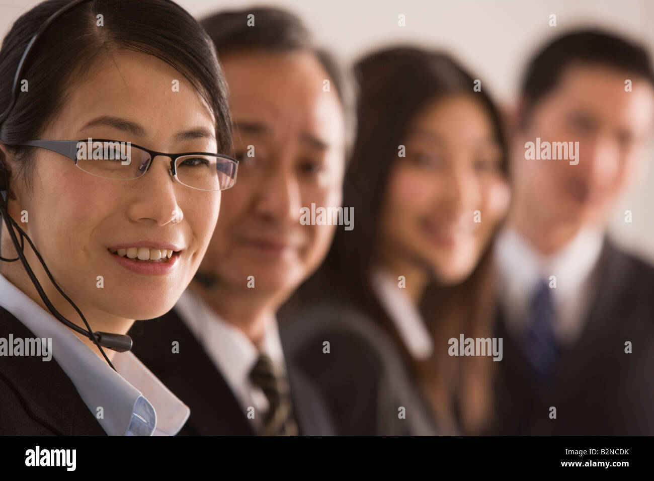 Portrait of four business executives wearing headsets Stock Photo - Alamy