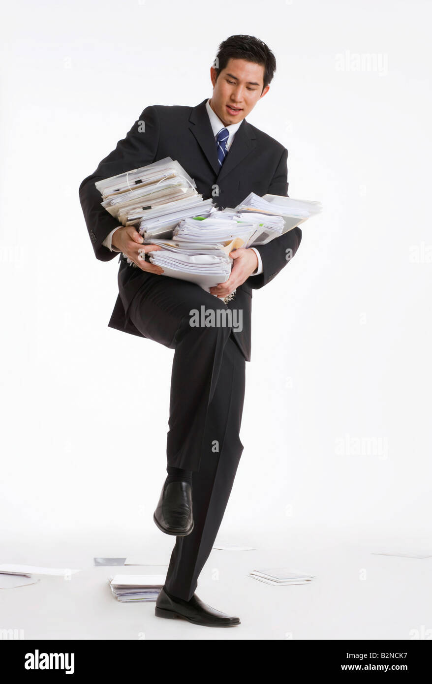 Businessman struggling to carry a stack of files Stock Photo - Alamy
