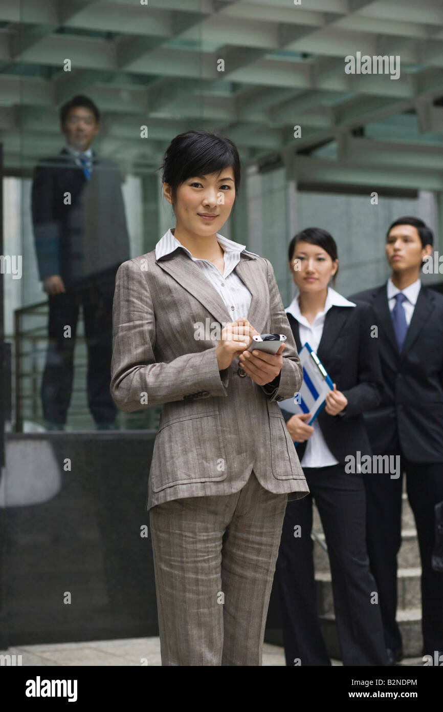 Portrait of a businesswoman operating a personal data assistant with ...