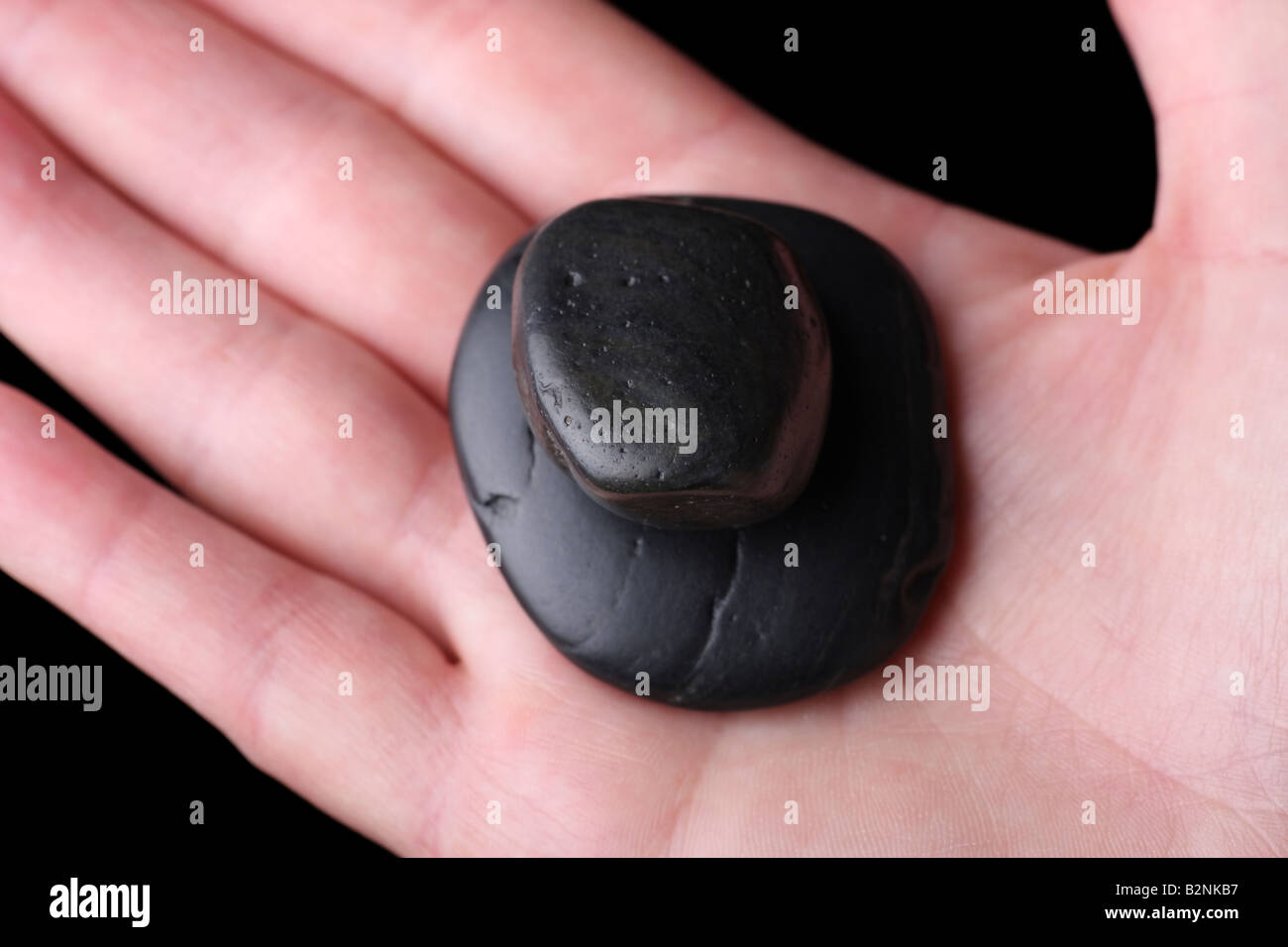 massage stones in hand Stock Photo - Alamy