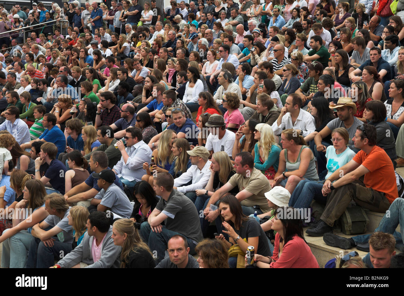 Crowd of people sitting outside UK Stock Photo - Alamy