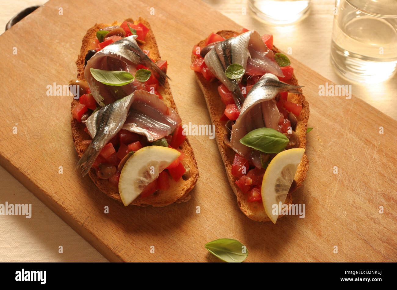 Toasted bread with tomatoes and pickled anchovies, Italy Stock Photo ...