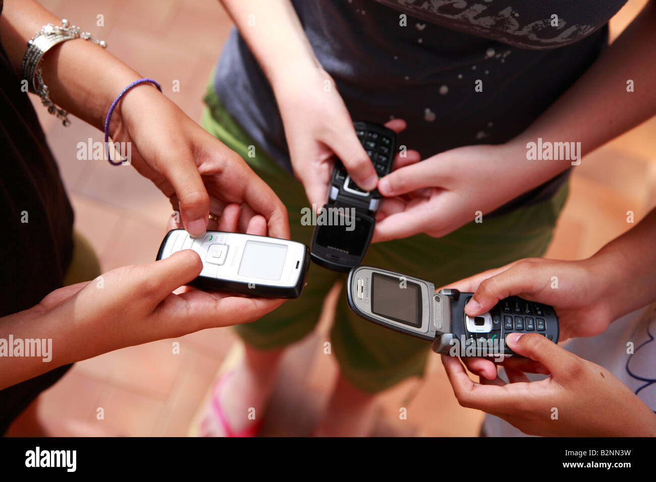 Three girls use their mobile phones hi-res stock photography and images ...