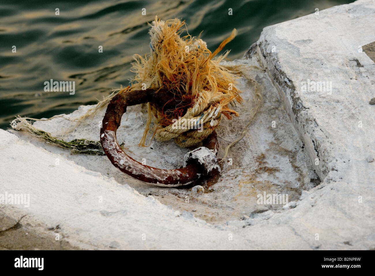 Tow rope anchor ring at port of samos at sunset Stock Photo - Alamy