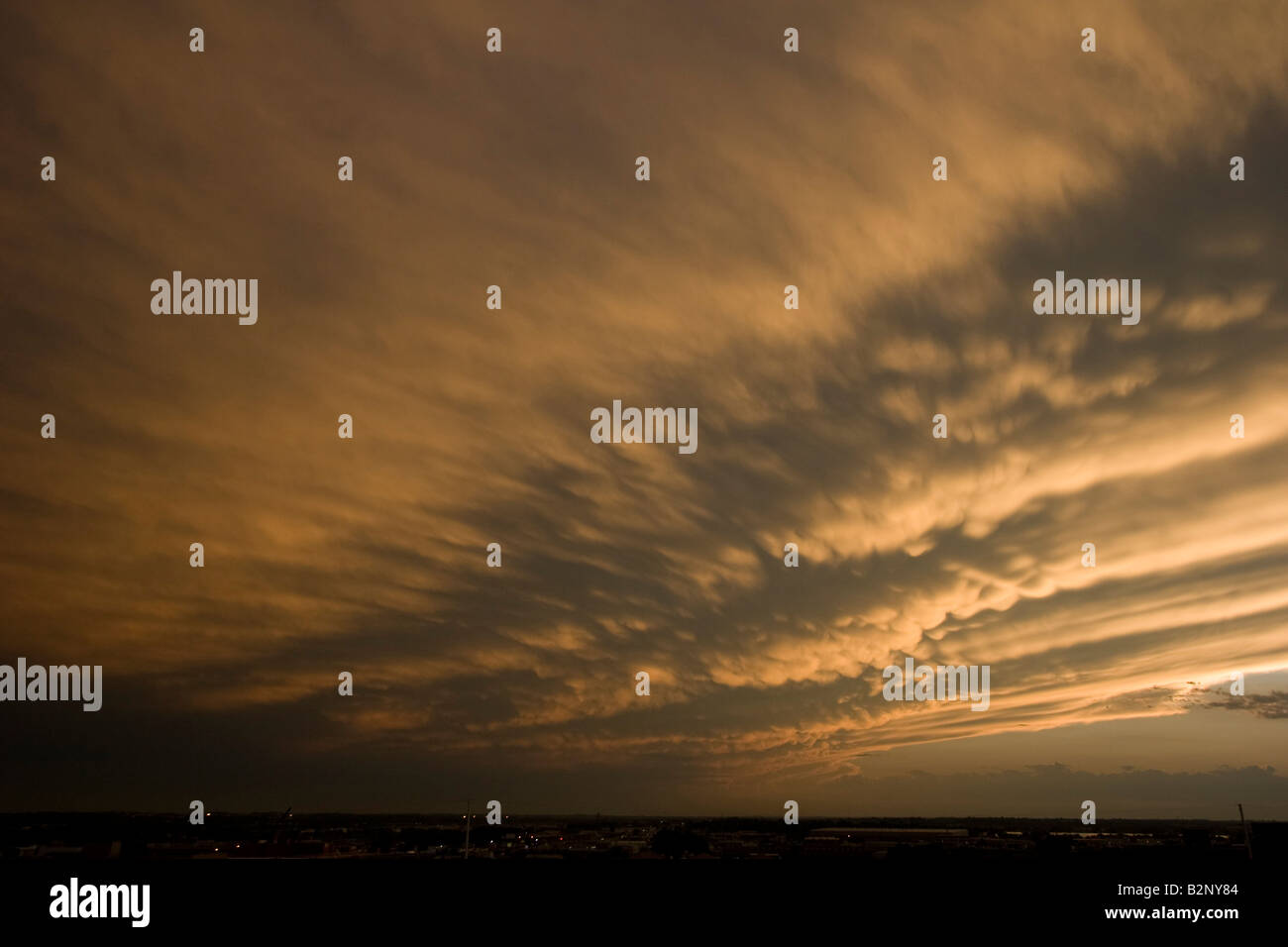 The underside of a thunderstorm anvil with mammatus clouds at sunset ...