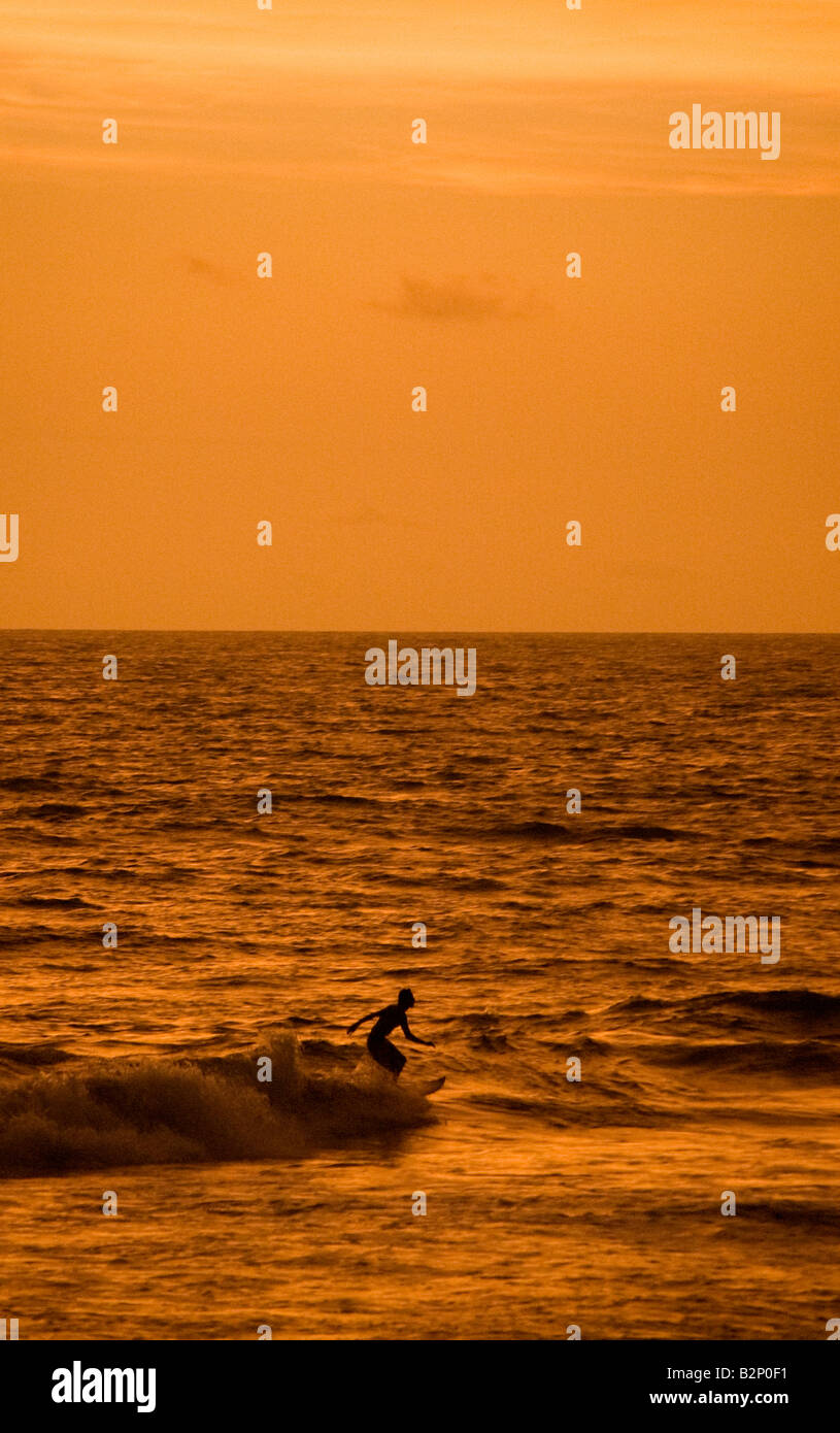 Surfer at sunset Stock Photo - Alamy