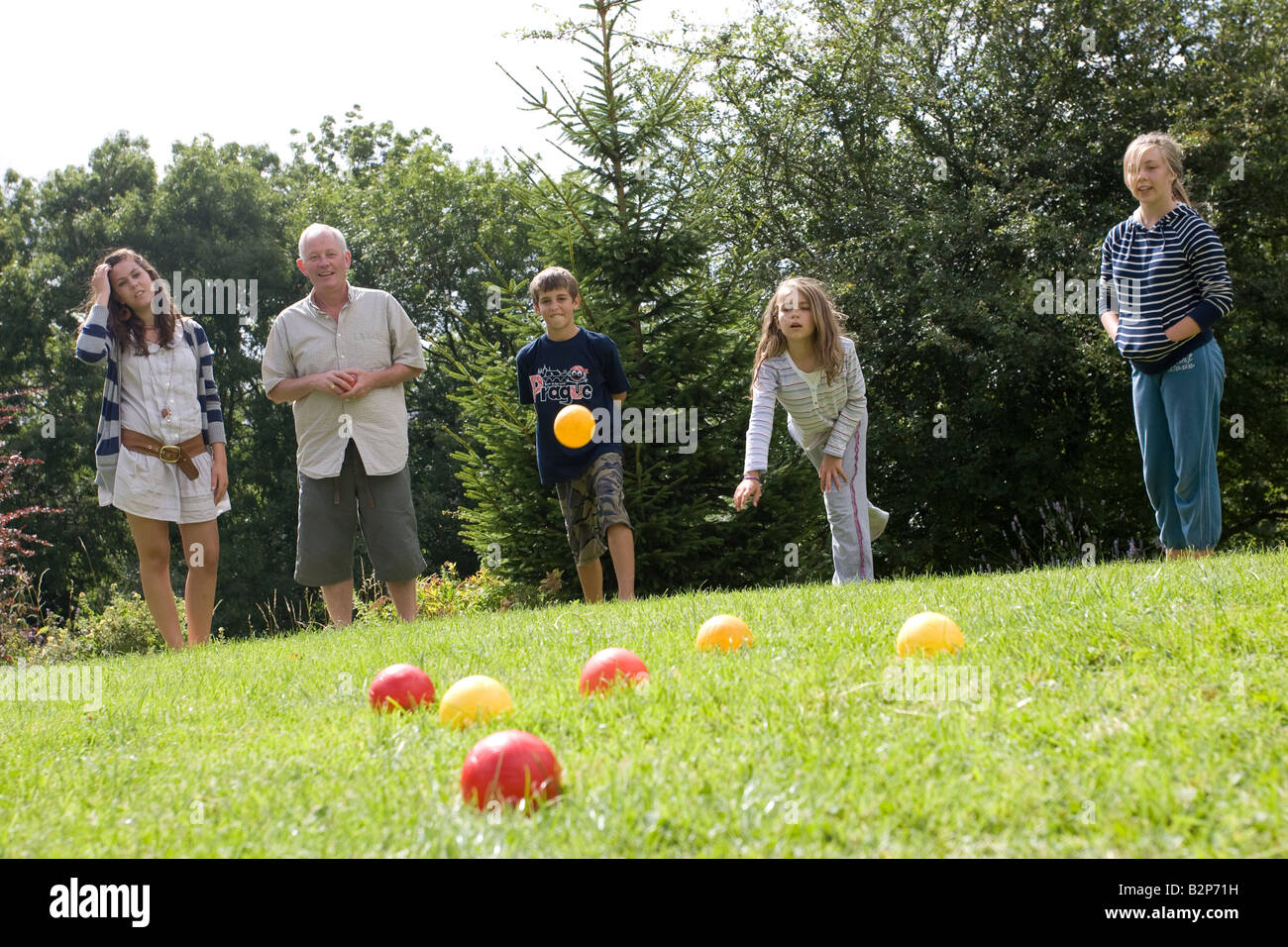 Family playing boule on lawn with coloured plastic balls Cotswolds UK ...