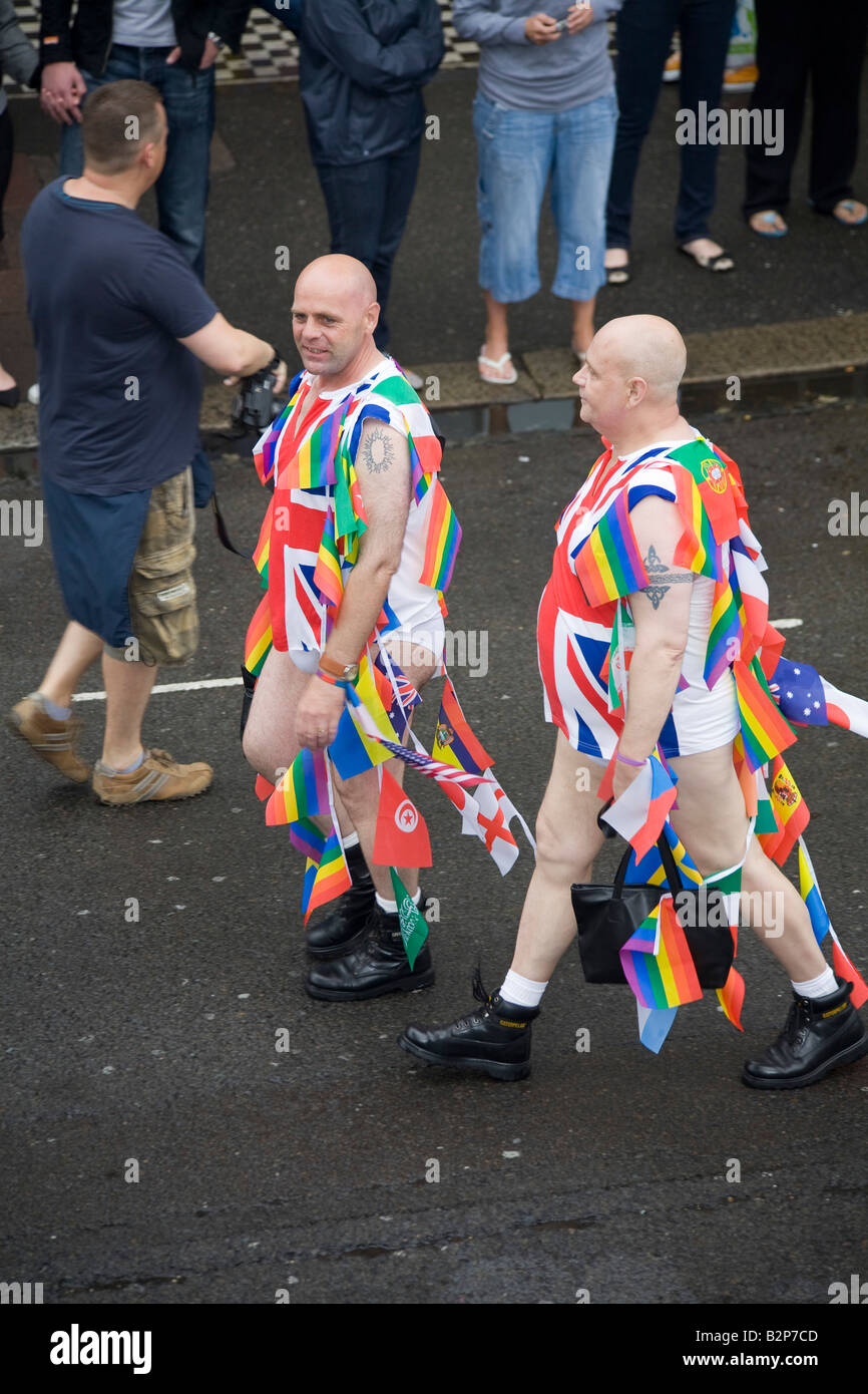 Two men walk along draped in Union Jack flags in Brighton's Gay Pride ...