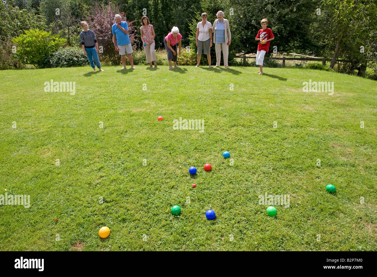 Family playing boules on lawn with coloured plastic balls Cotswolds UK ...