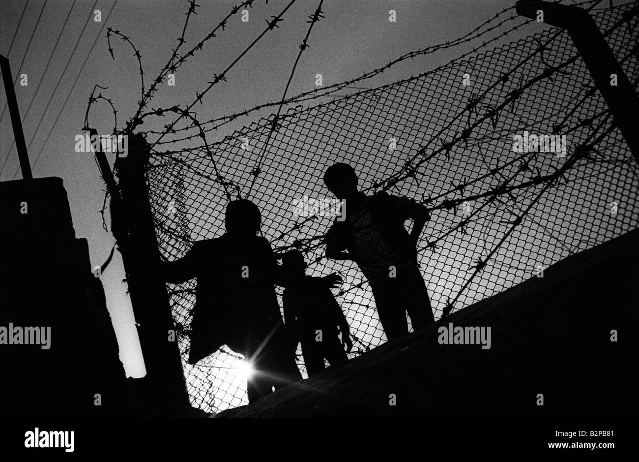 kurdish children play on a barbed wire fence near the Iraqi border in ...