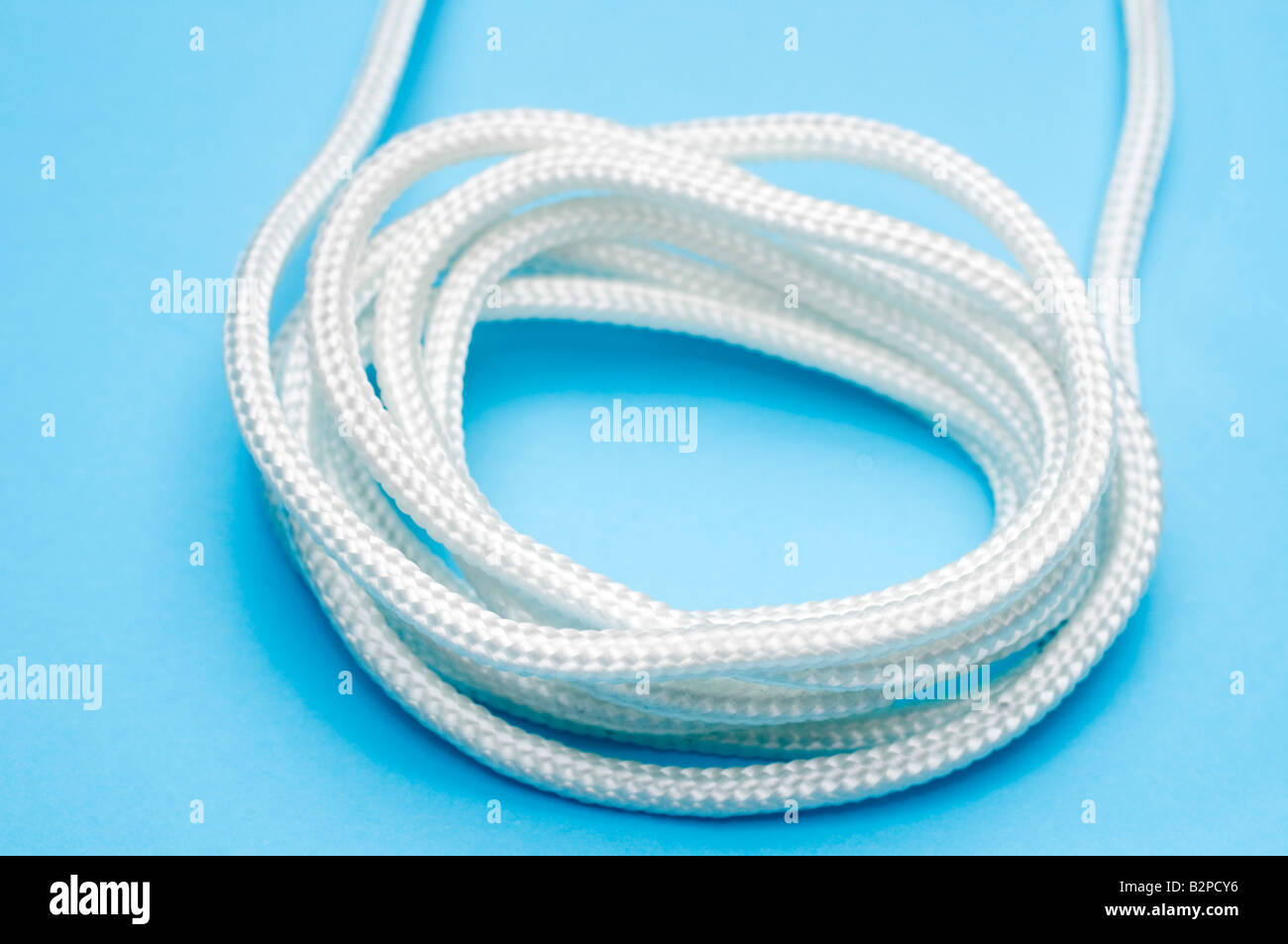 Rolled up rope on blue background Stock Photo - Alamy