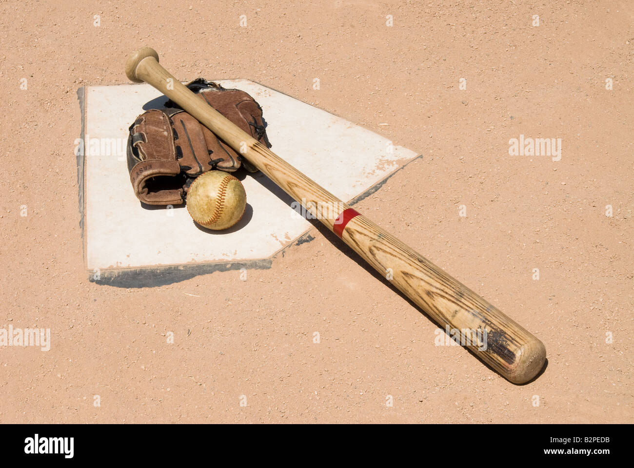 Baseball equipment sitting on home plate set up as a conceptual image ...