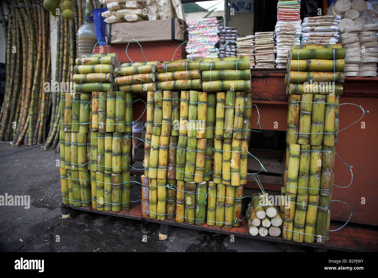 Raw sugar cane sticks and other sweets on sale in the town of Banos de ...